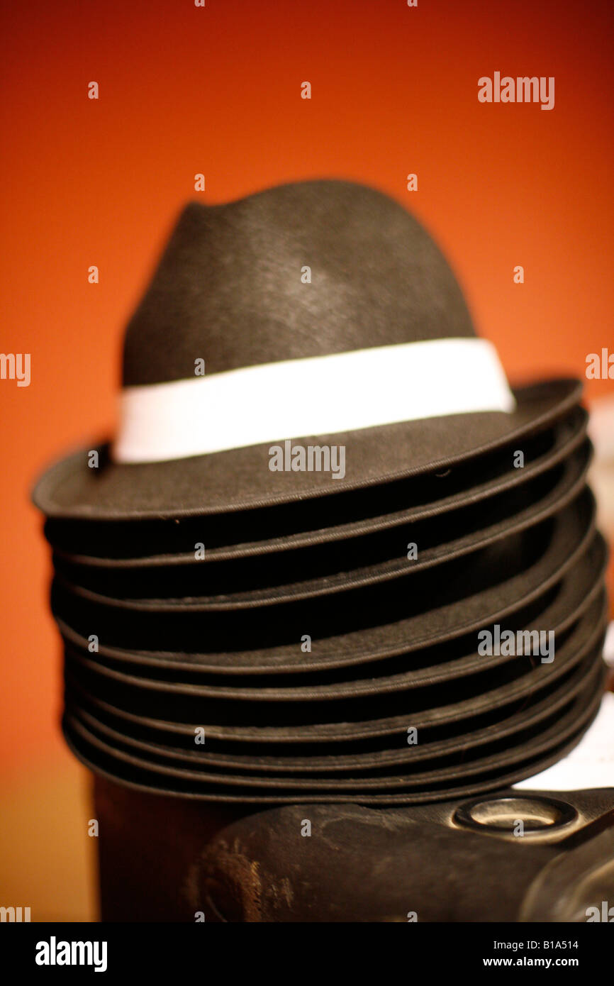 Stack of black hats against a red background Stock Photo - Alamy