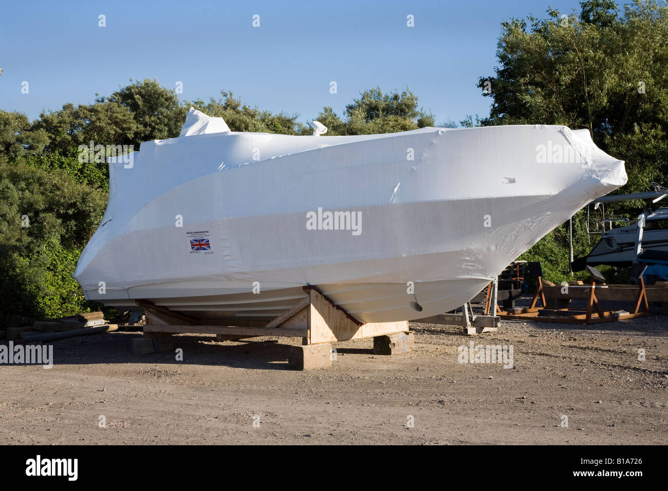 Heat-sealed white shrink wrapped plastic protecting new boat ready for ...