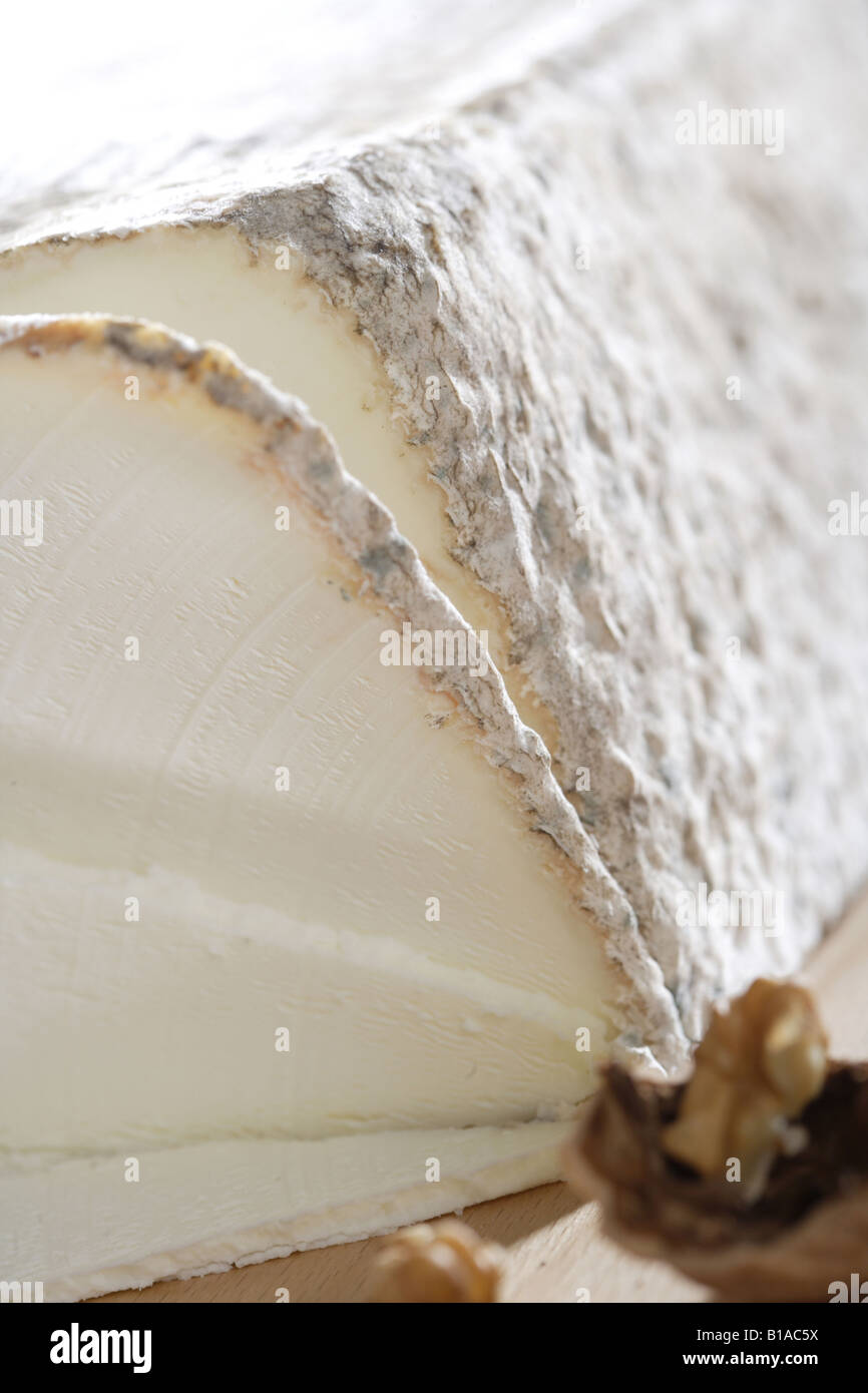 Cutting goat cheese with a cheese slicer (detail, vertical Stock Photo ...