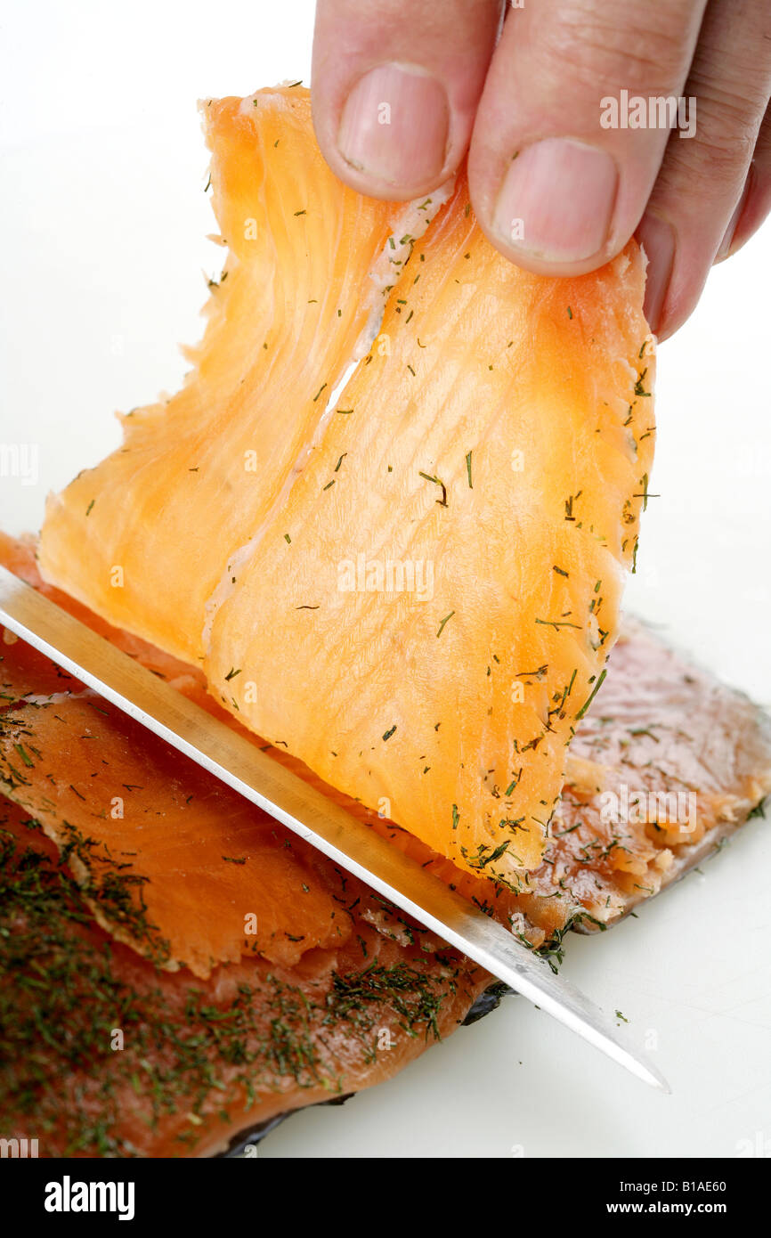 Cutting marinated salmon into thin slices (vertical Stock Photo - Alamy