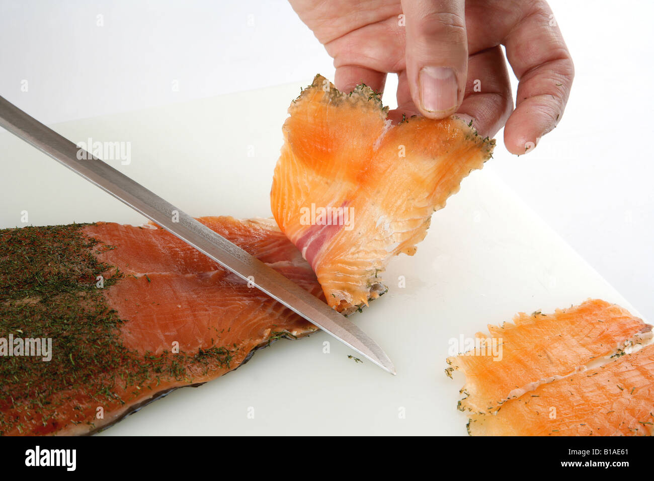 Cutting marinated salmon into thin slices Stock Photo - Alamy