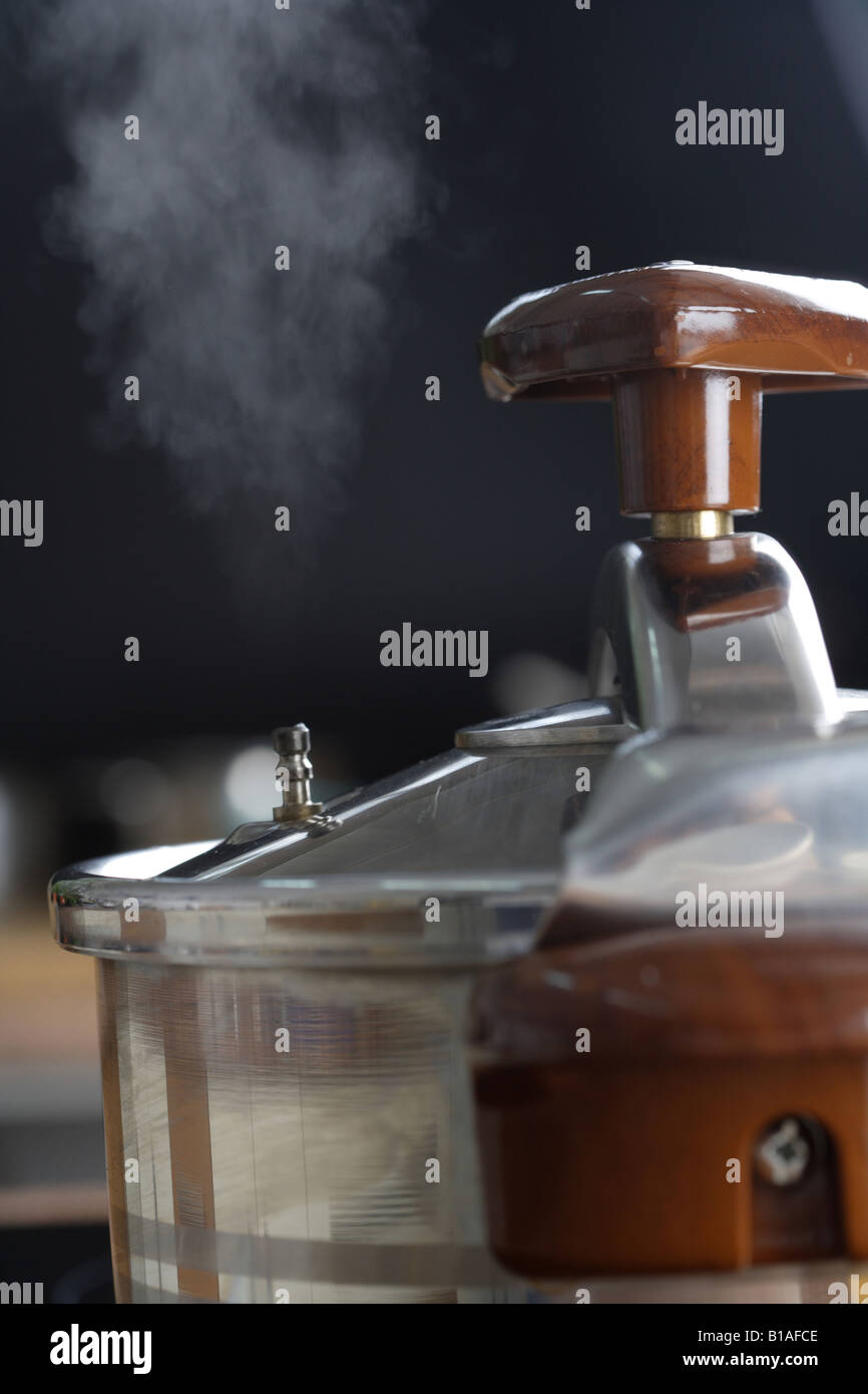 Steam releasing from the pressure cooker (vertical Stock Photo - Alamy