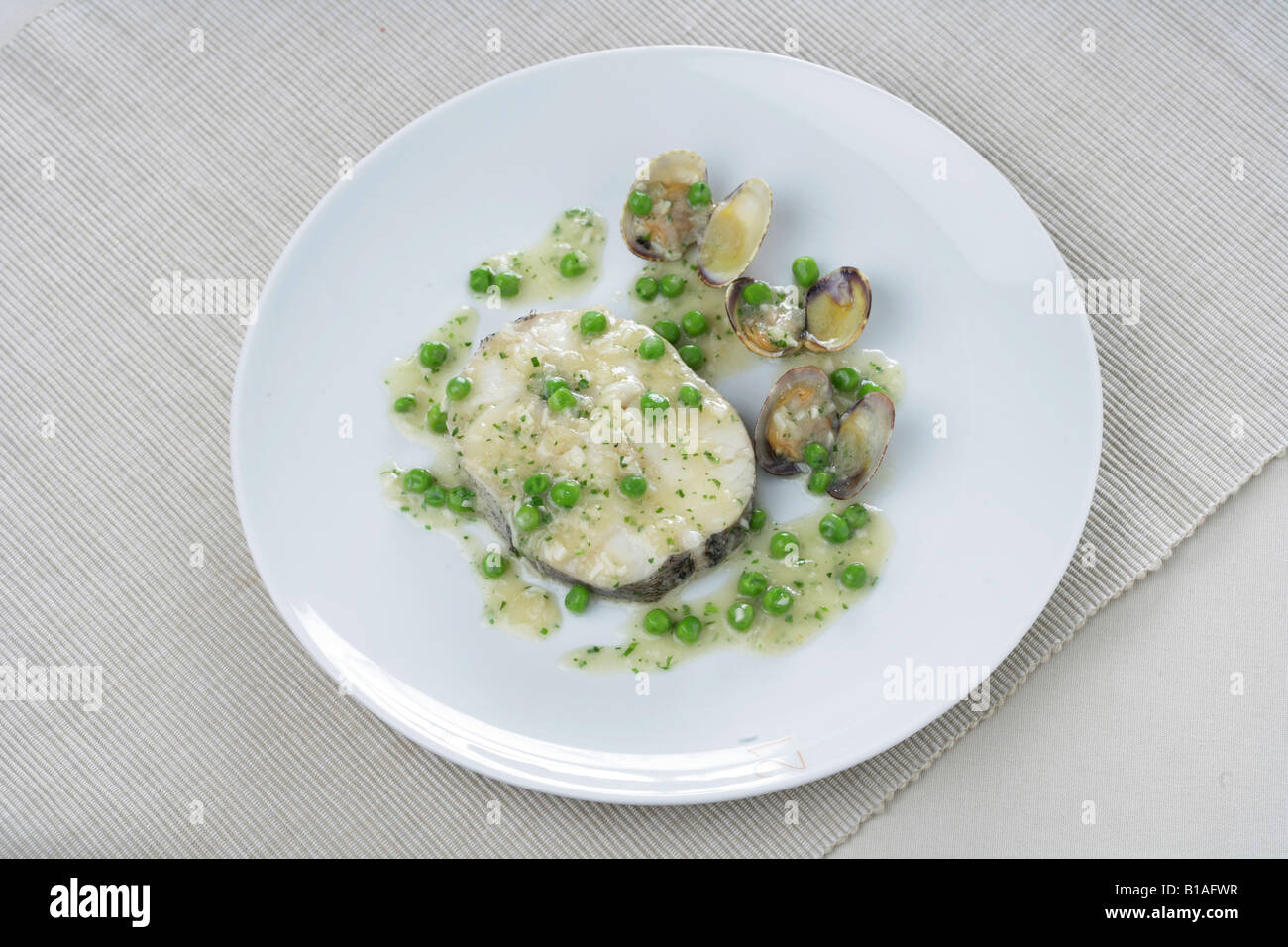 Hake with green sauce Basque style Stock Photo - Alamy