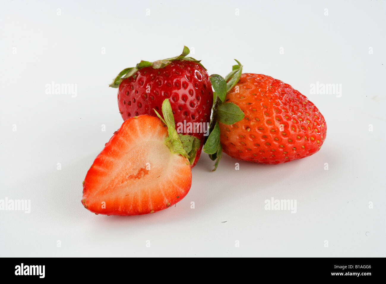Strawberries one strawberry cut in half Stock Photo - Alamy