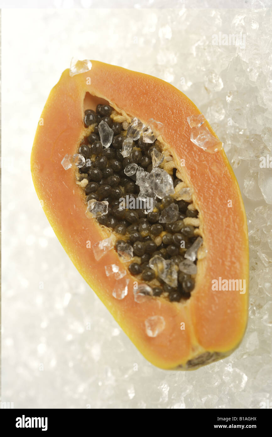 A large papaya cut in half over crushed ice Stock Photo - Alamy