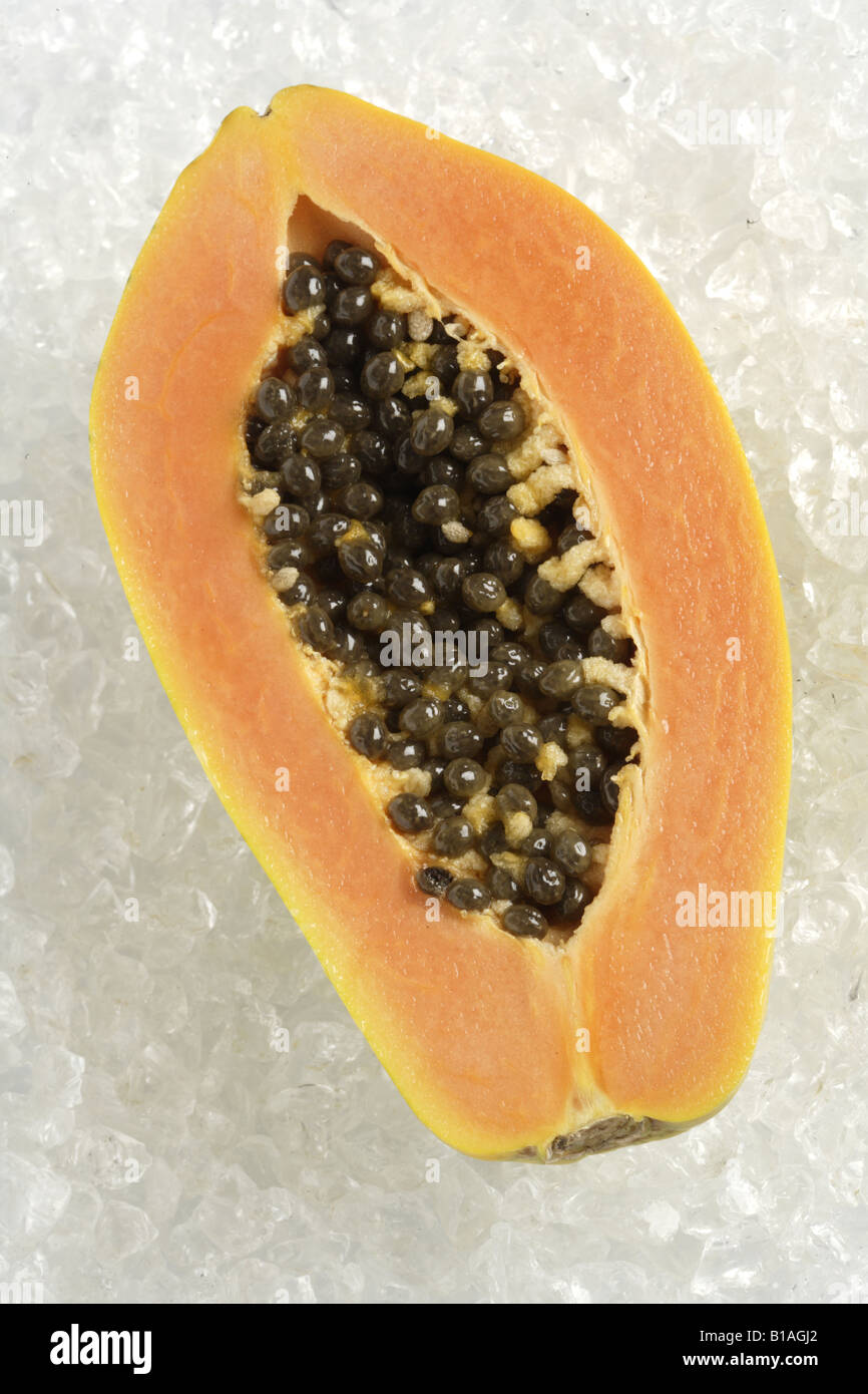 A large papaya cut in half over crushed ice Stock Photo - Alamy