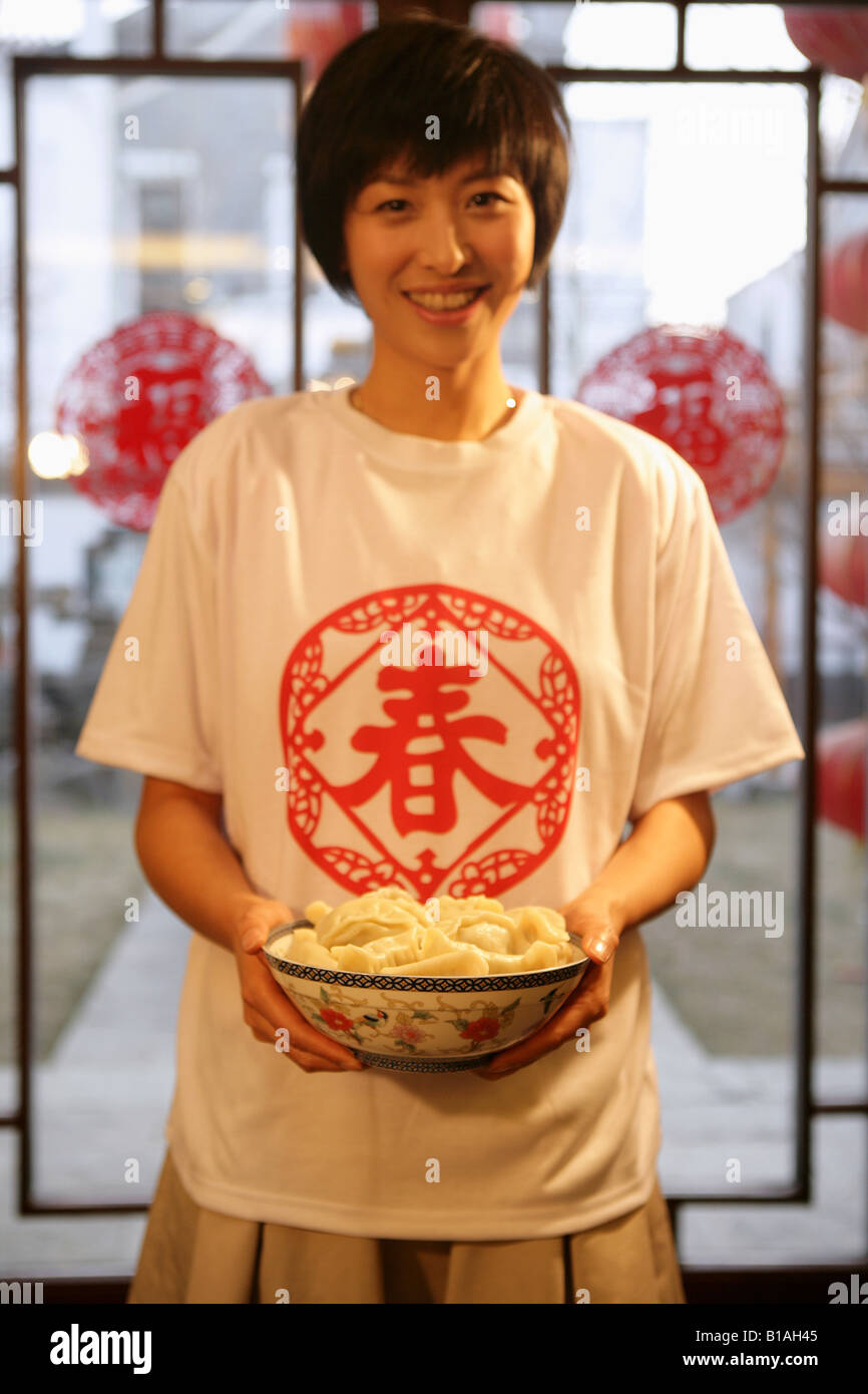 Chinese young woman holding a bowl of Chinese dumpling Stock Photo - Alamy