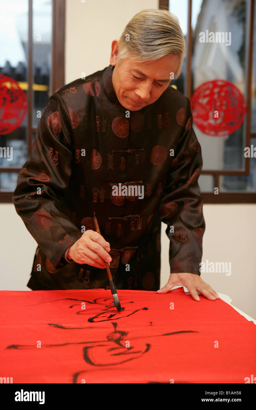 Chinese mature man writing Chinese couplet Stock Photo - Alamy