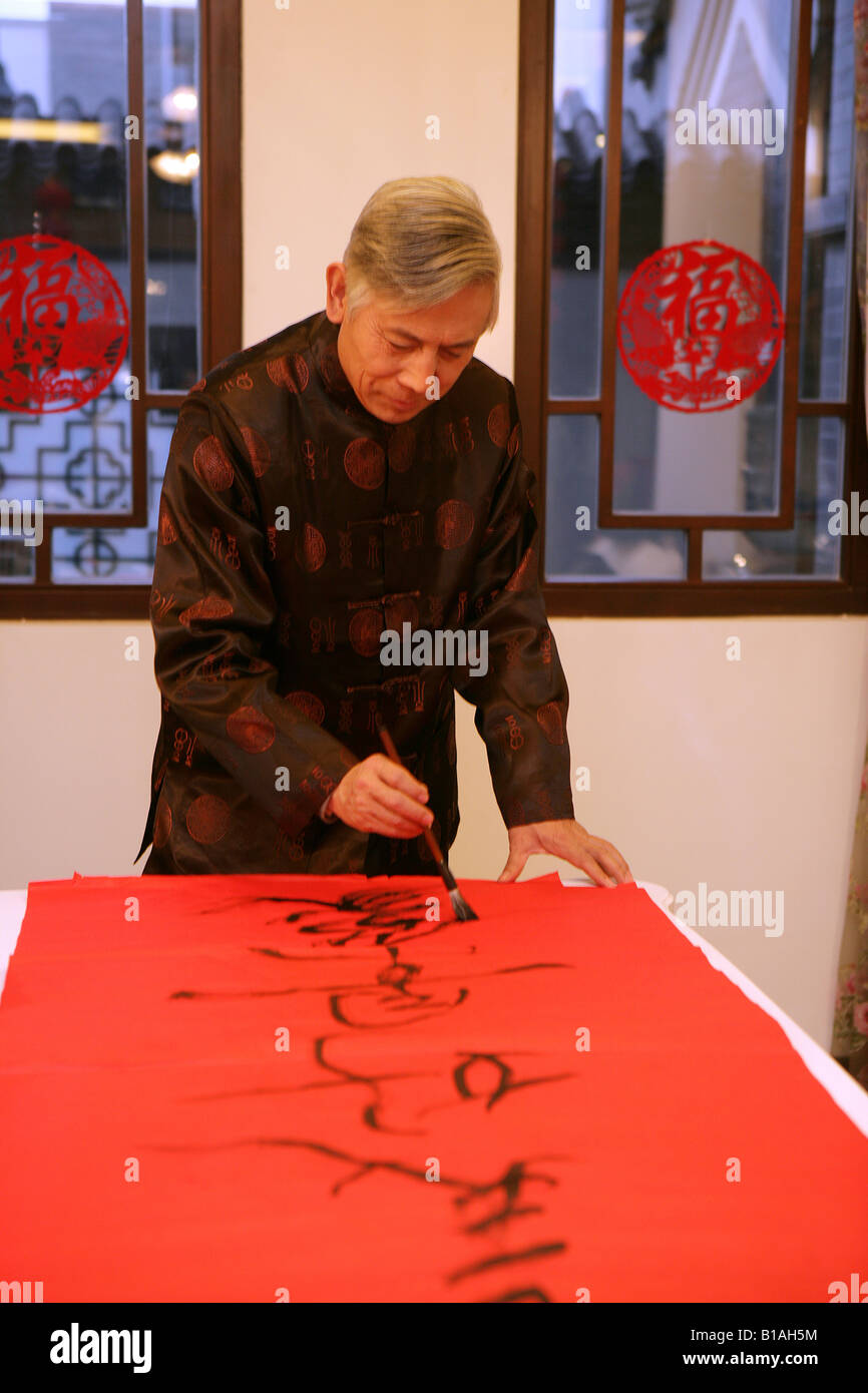 Chinese mature man writing Chinese couplet Stock Photo - Alamy