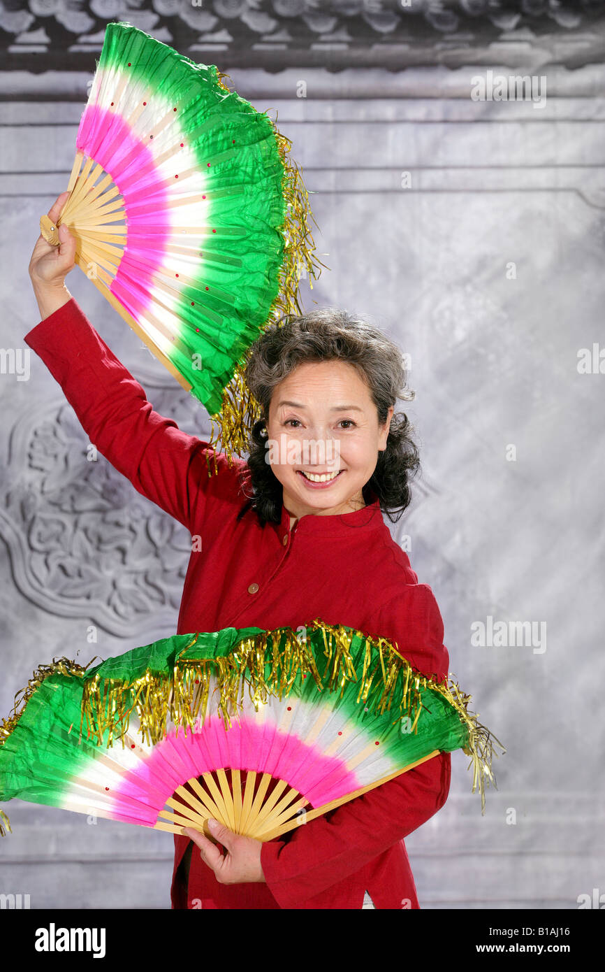 oriental senior woman dancing with fan Stock Photo - Alamy