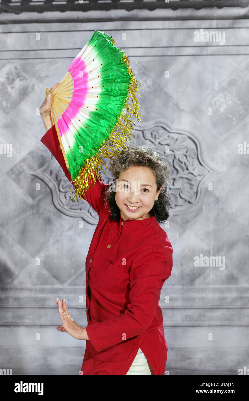 oriental senior woman dancing with fan Stock Photo - Alamy