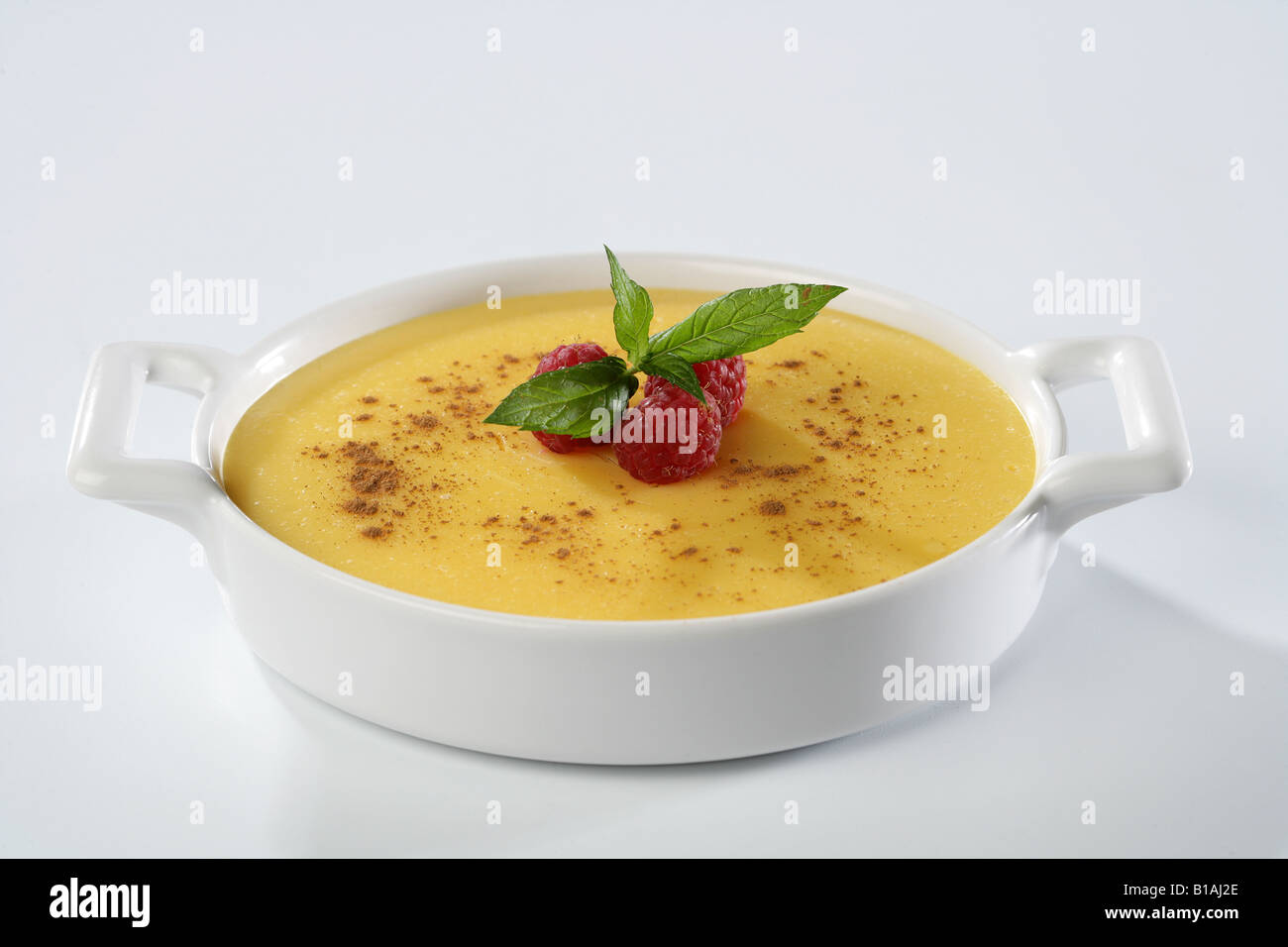 Vanilla cream with raspberries and cinnamon Stock Photo - Alamy