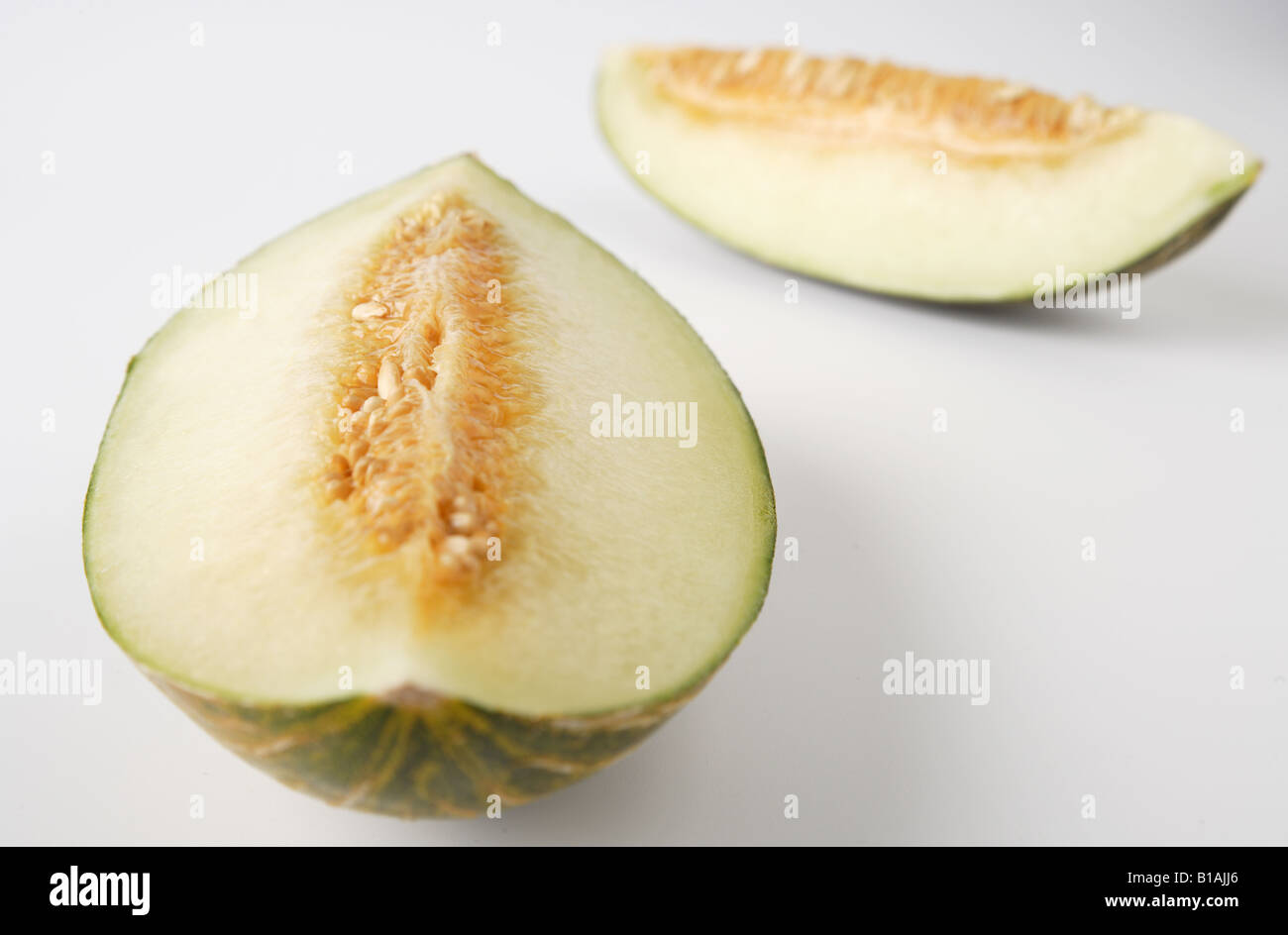 A melon cut in half and a slice of melon Stock Photo - Alamy