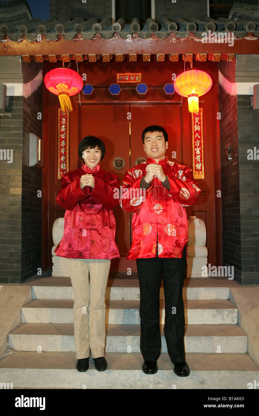 Chinese family gesturing welcome at the gate celebrating Chinese New ...