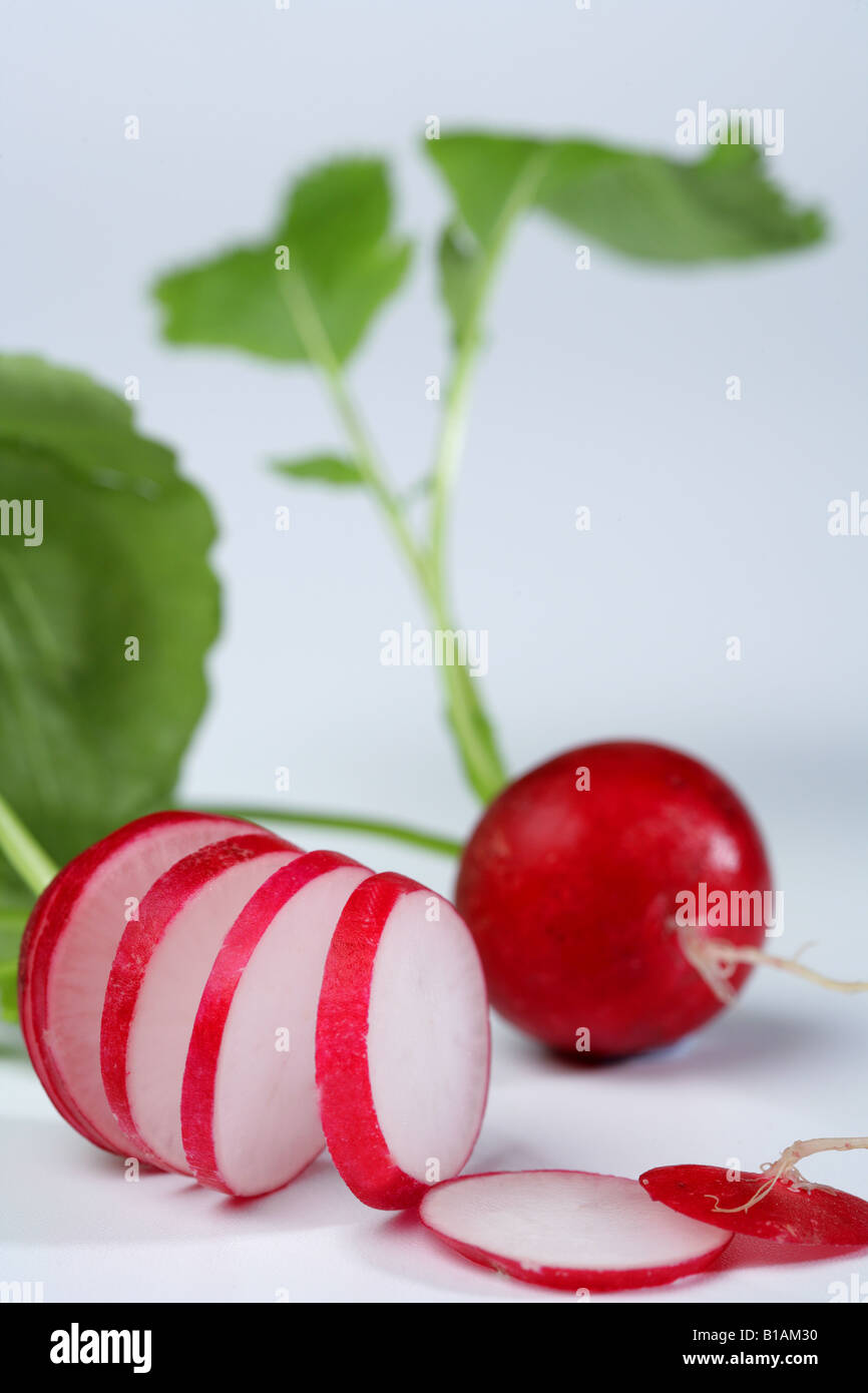 Two radishes on white background, one sliced Stock Photo - Alamy