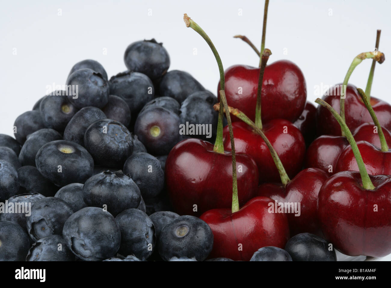 Blueberries and cherries on white background Stock Photo - Alamy