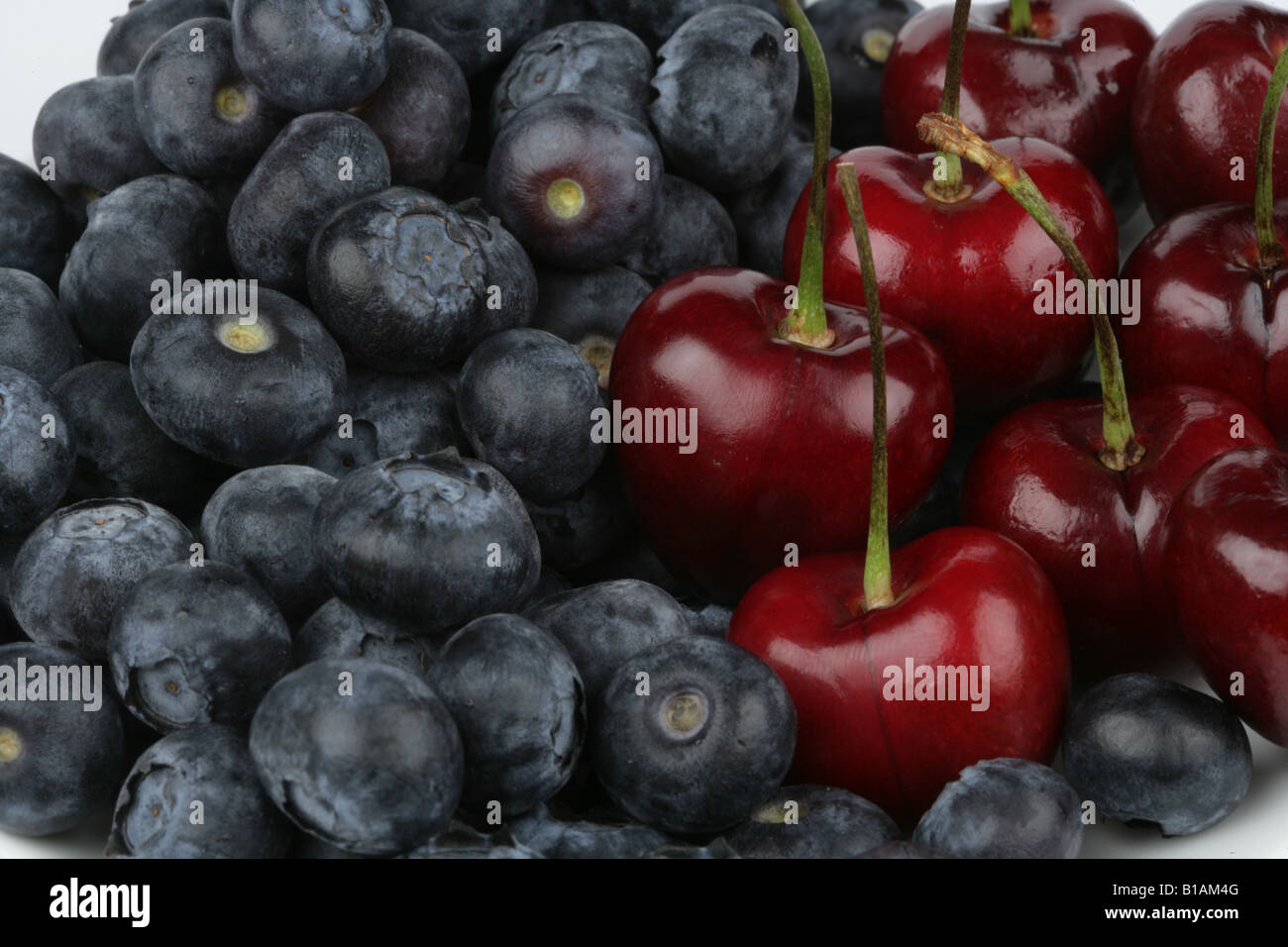 Blueberries and cherries on white background Stock Photo - Alamy