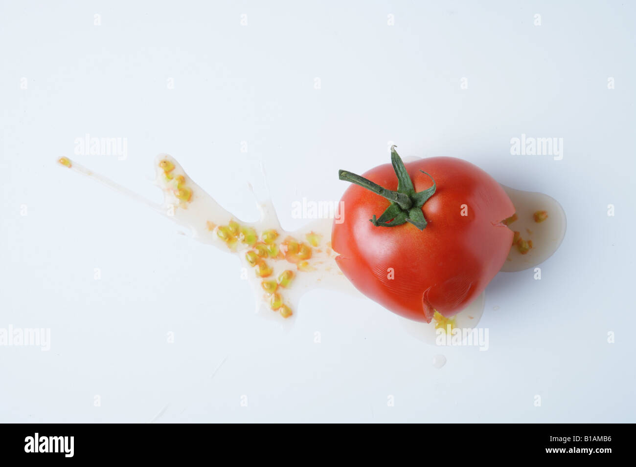Broken red tomato on white background Stock Photo - Alamy