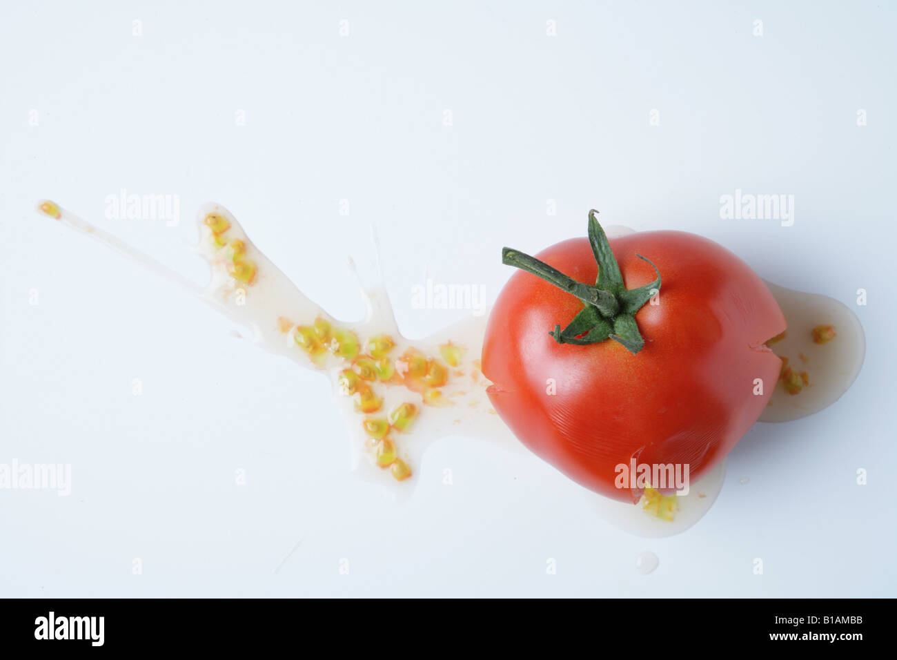 Broken red tomato on white background Stock Photo - Alamy