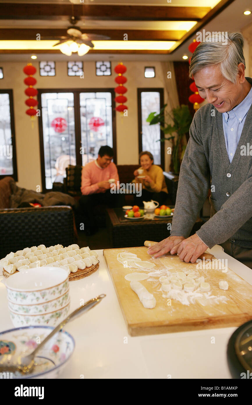 Chinese mature man make Chinese dumpling on New Year's Eve Stock Photo ...