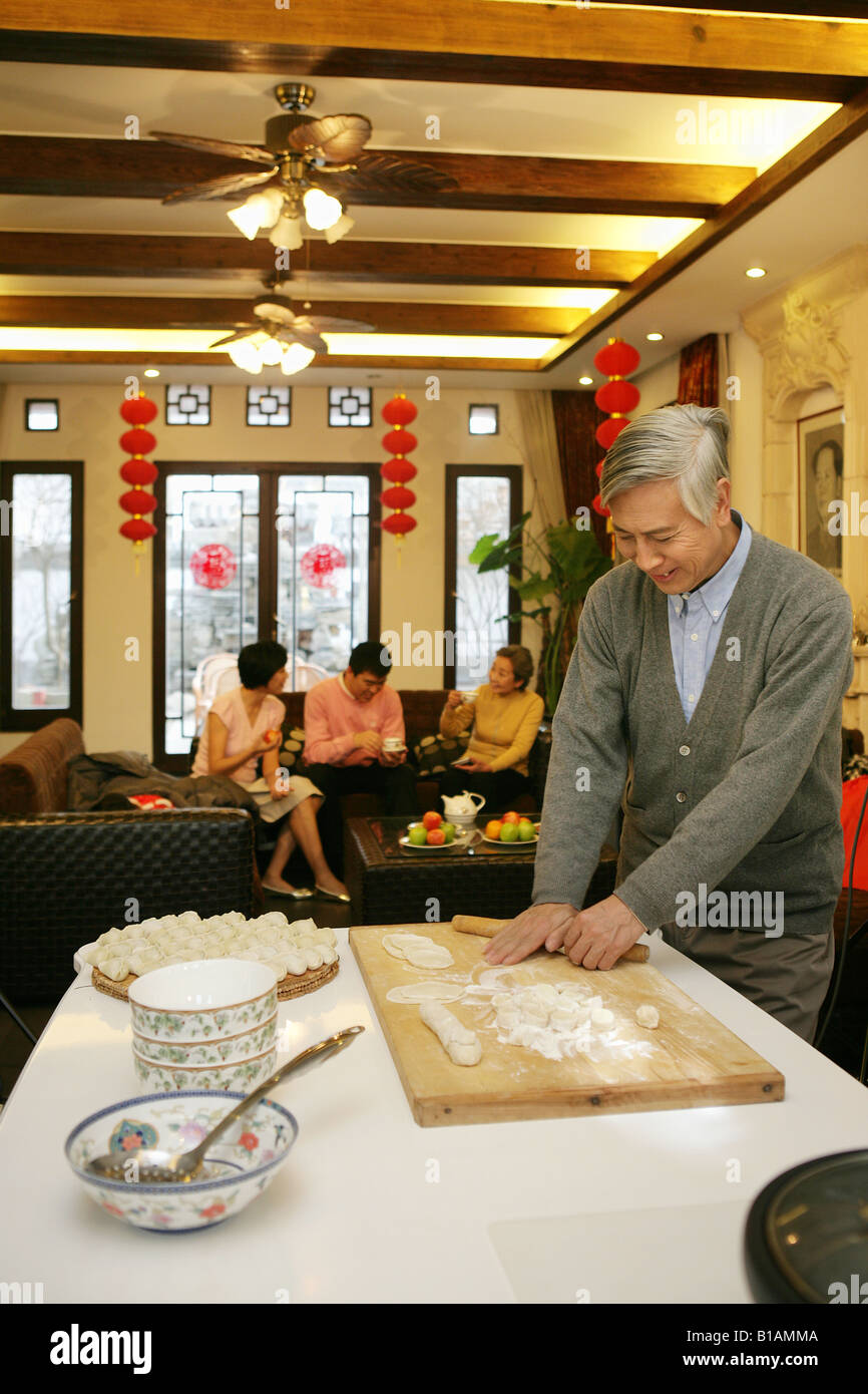 Chinese mature man make Chinese dumpling on New Year's Eve Stock Photo ...