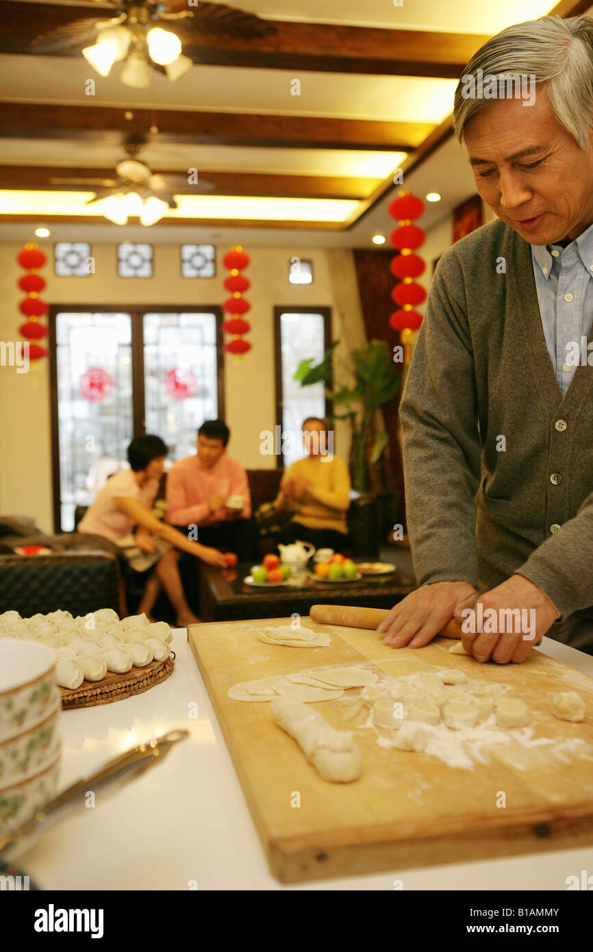 Chinese mature man make Chinese dumpling on New Year's Eve Stock Photo ...
