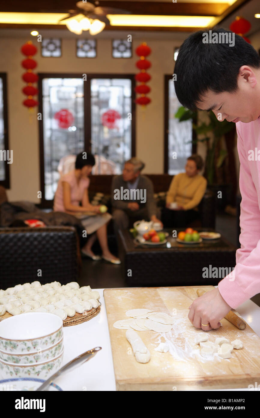 Chinese mid adult man making Chinese dumpling on New Year's Eve Stock ...