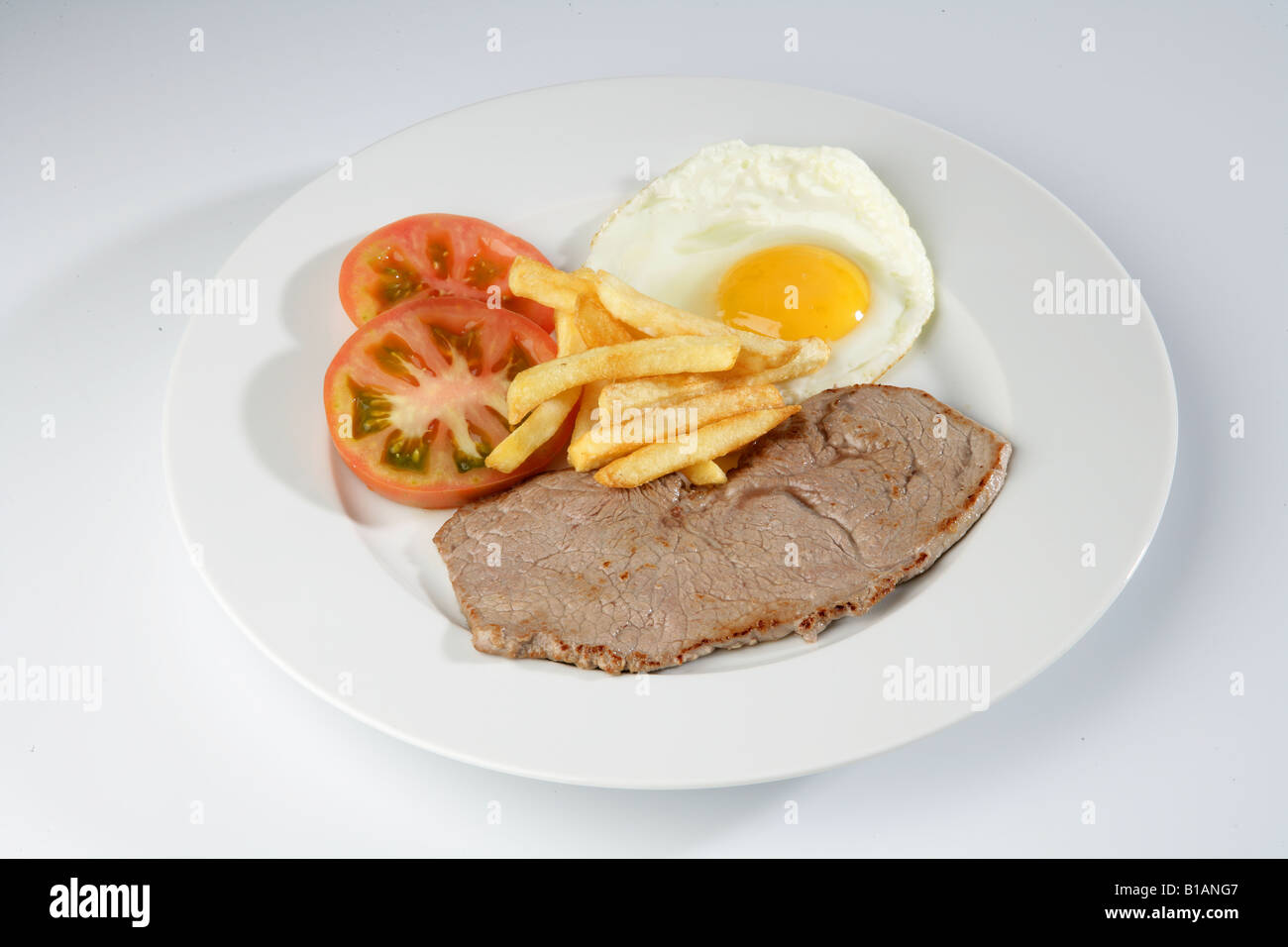 Mixed main course with with veal fillet, fried egg, French fries and ...