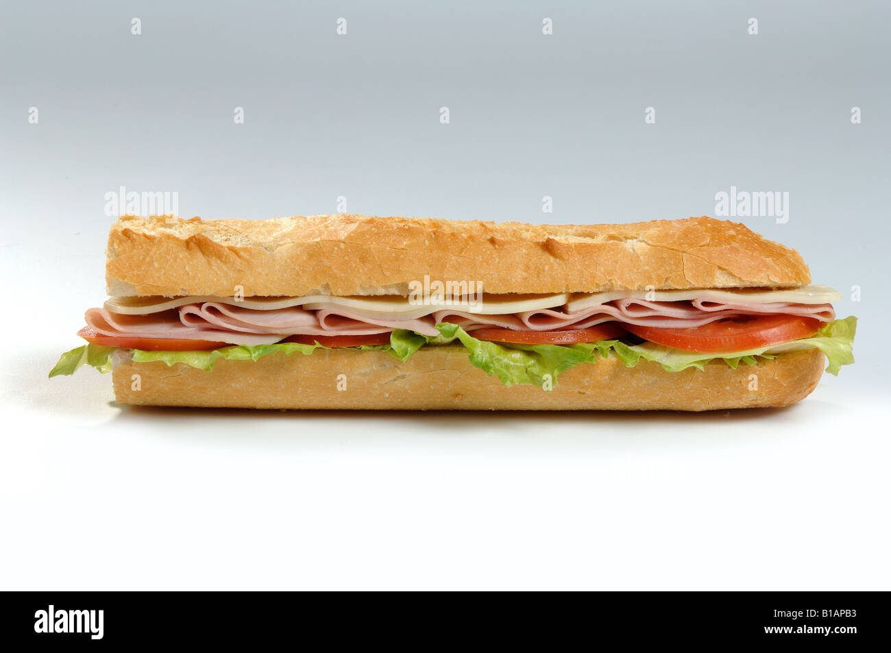Baguette sandwich of cooked ham, cheese, lettuce, and tomato Stock ...