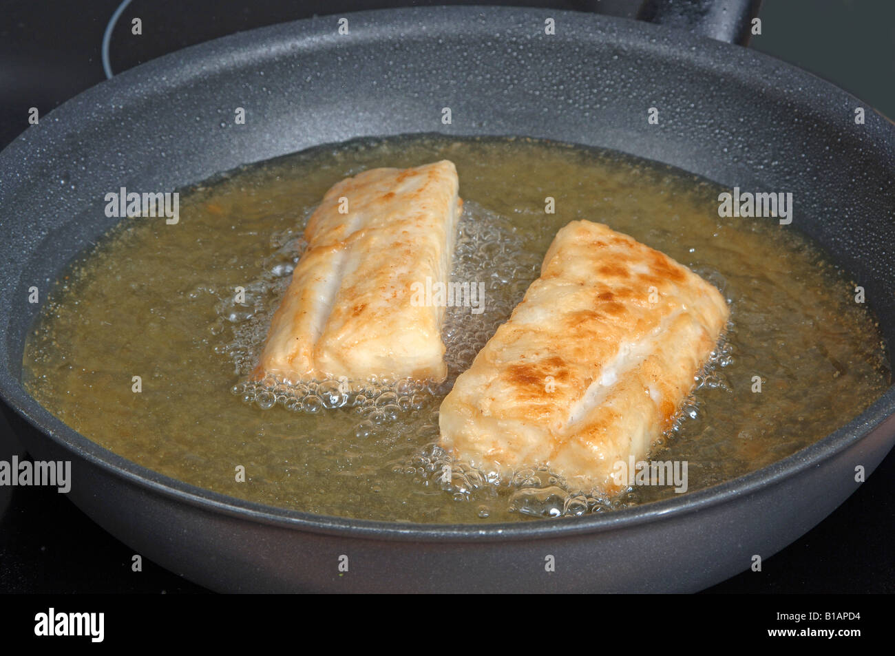 Frying floured cod Stock Photo - Alamy