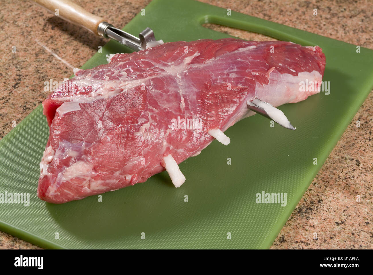 Plunging the larding needle into the beef Stock Photo - Alamy