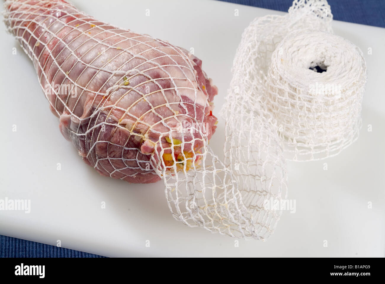 Tying a string around leg of lamb Stock Photo - Alamy