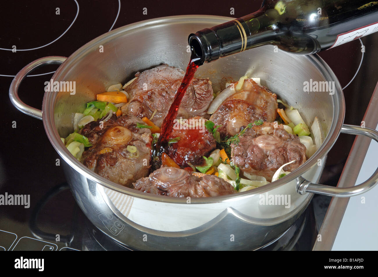 Pouring red wine over bull’s tail Stock Photo - Alamy