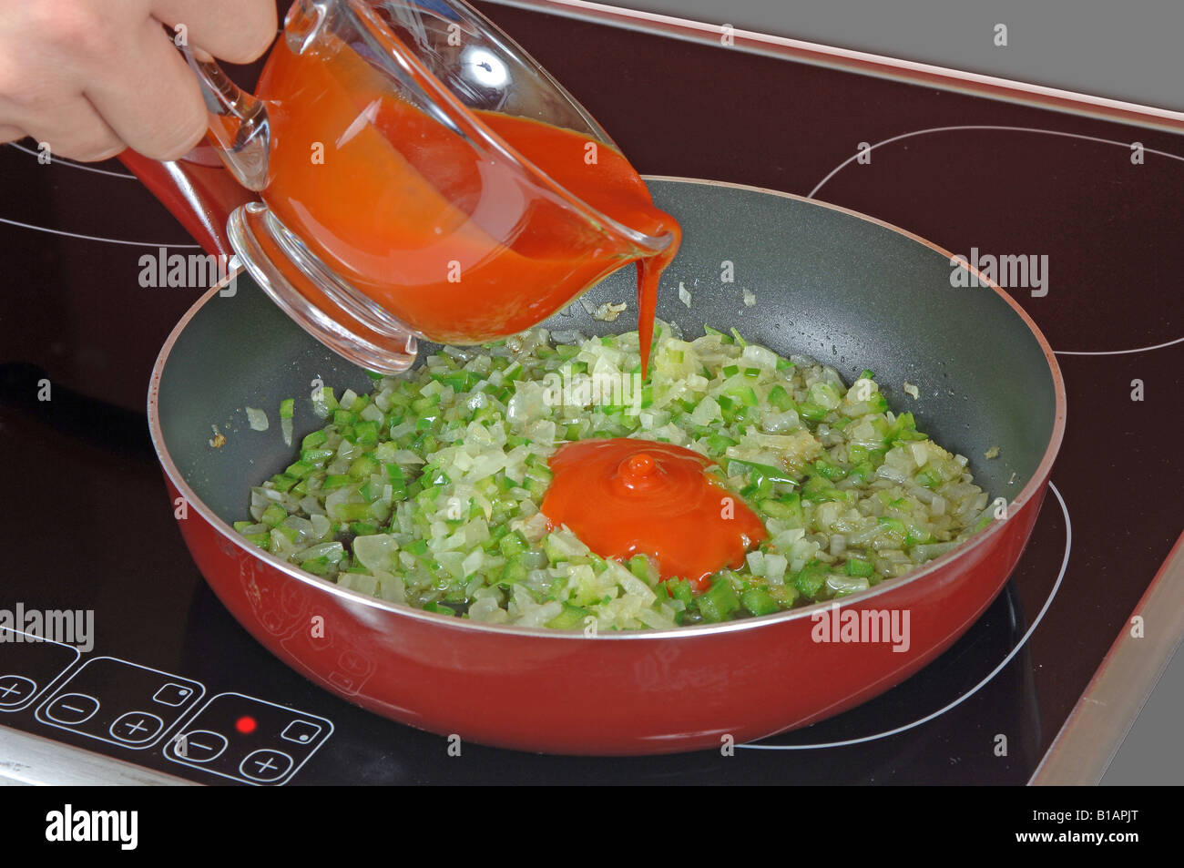 Adding tomato to typical sautéed ingredients Stock Photo - Alamy