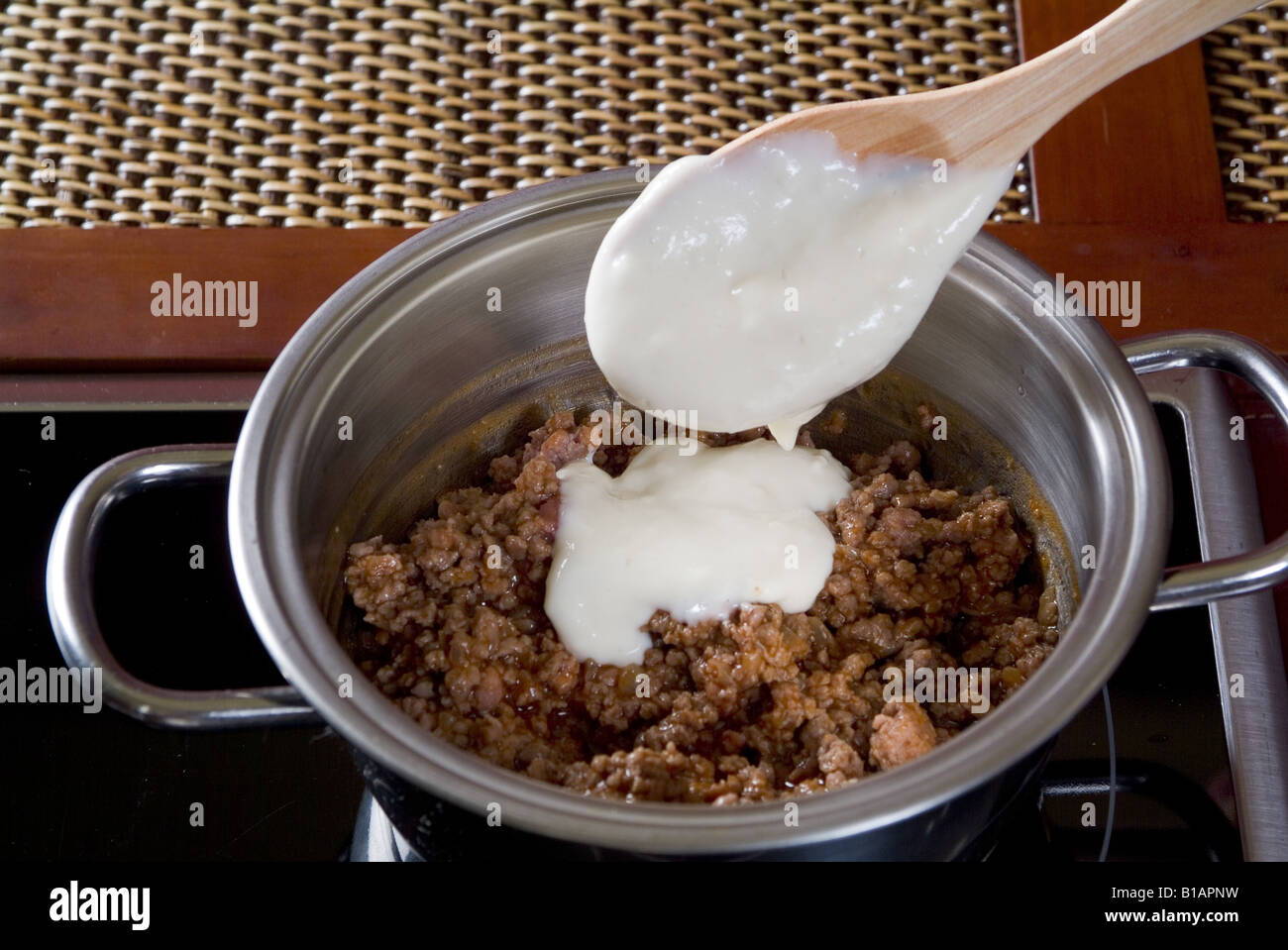Adding bechamel to minced beef Stock Photo - Alamy