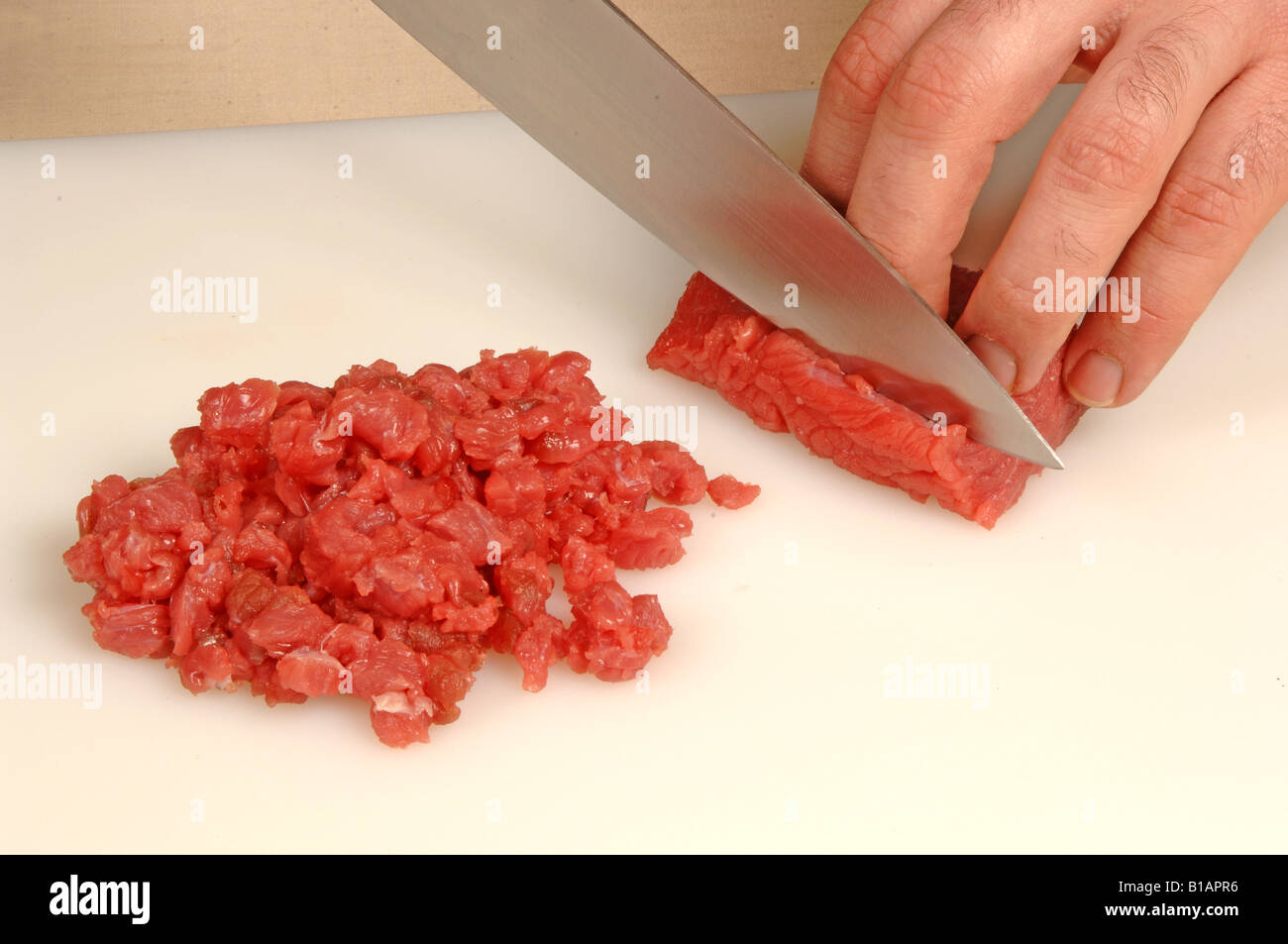 Chopping beef to make burger Stock Photo - Alamy