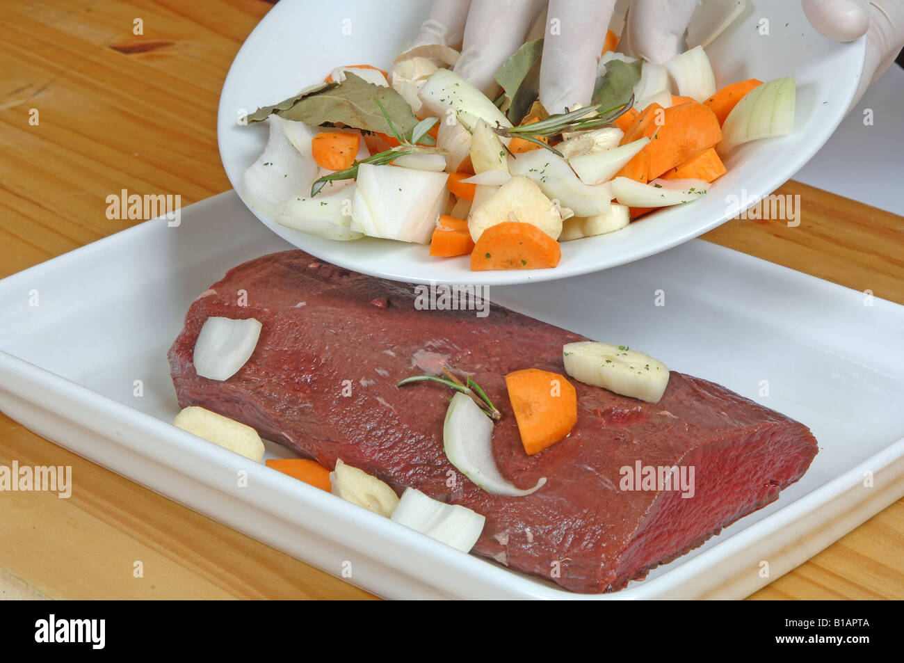 Adding vegetables to venison loin to marinate Stock Photo - Alamy