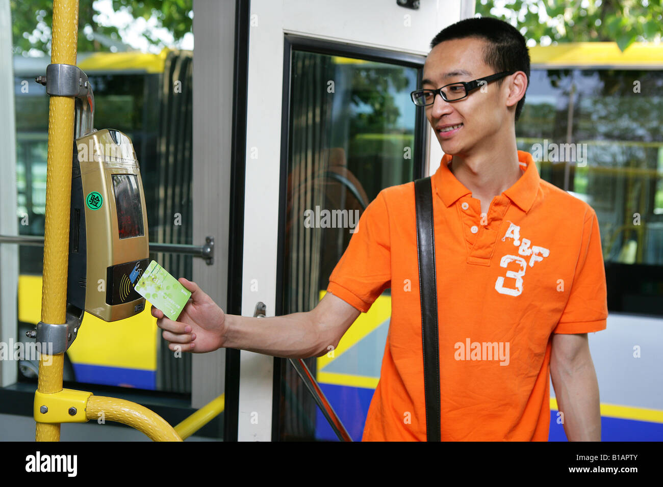 a chinese young man paying bus fare with a bus card Stock Photo - Alamy