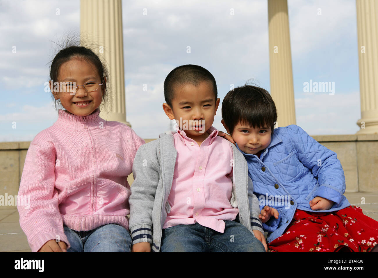 three chinese children sitting side by side Stock Photo - Alamy
