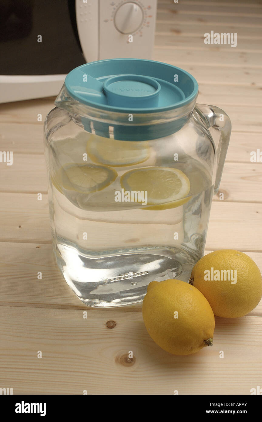 Glass jug of water with lemon slices Stock Photo - Alamy