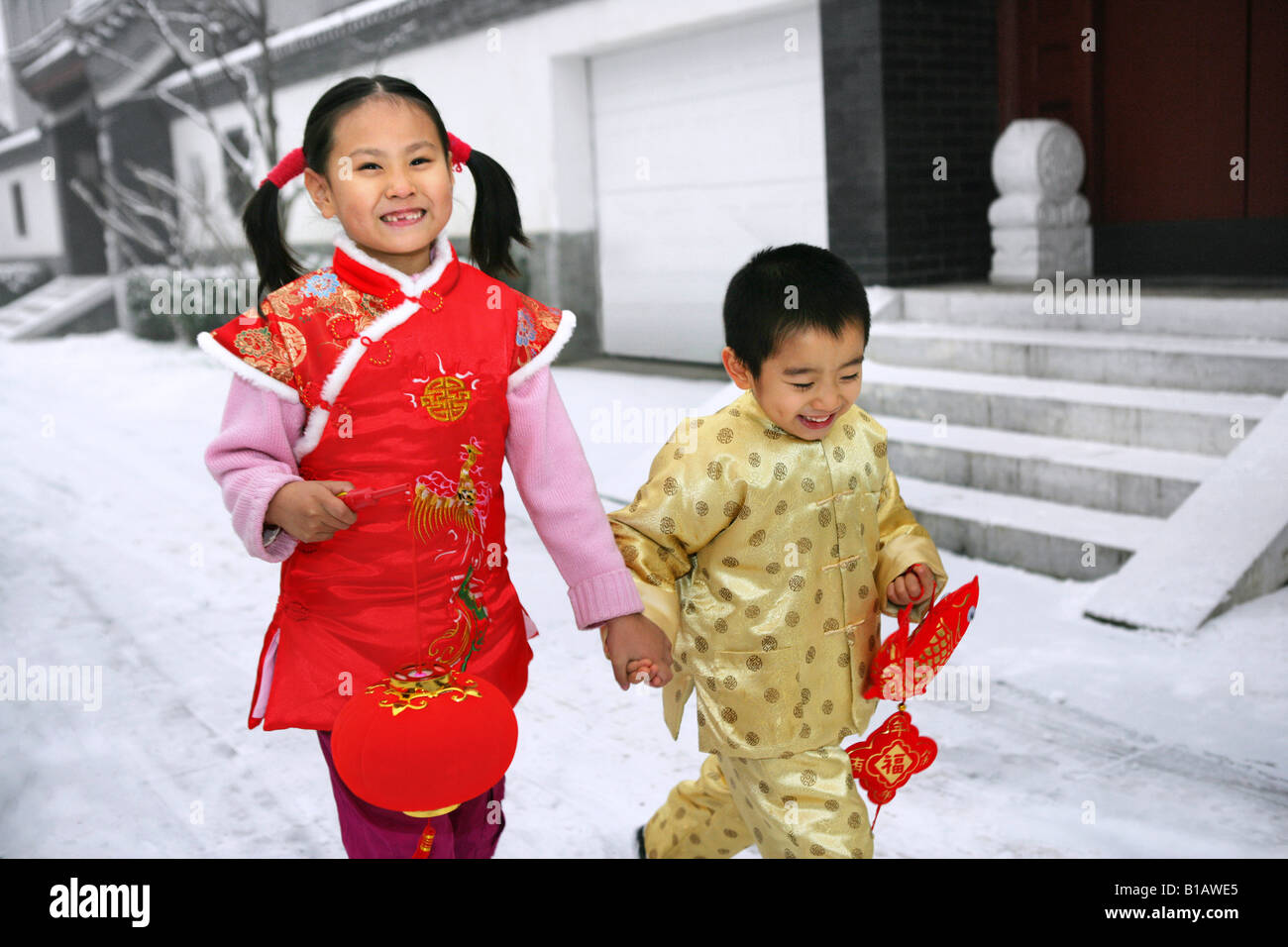 Two children(5-7 years) walking in front of chinese traditional houses ...