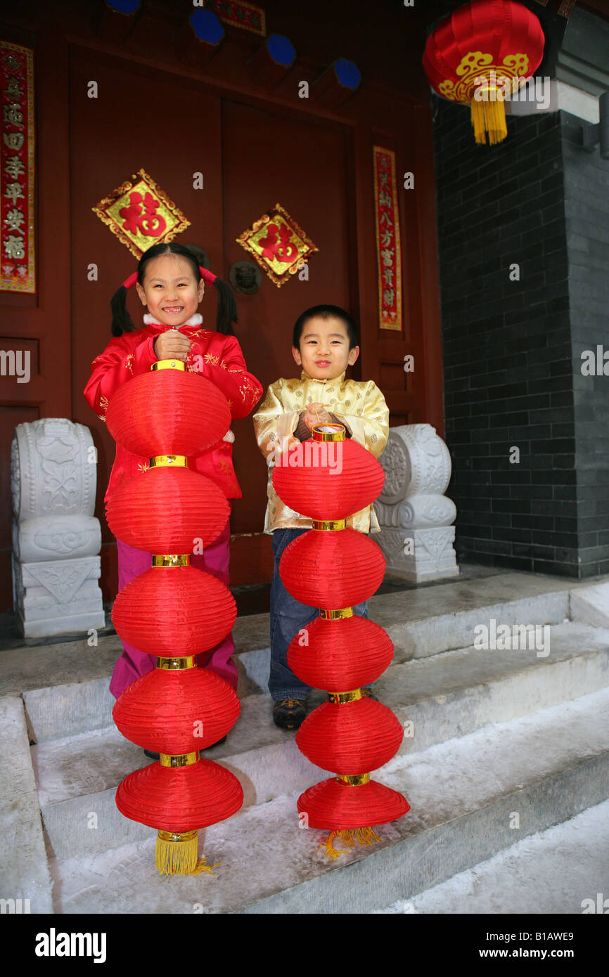 Two children(5-7 years) standing in front of chinese traditional house ...