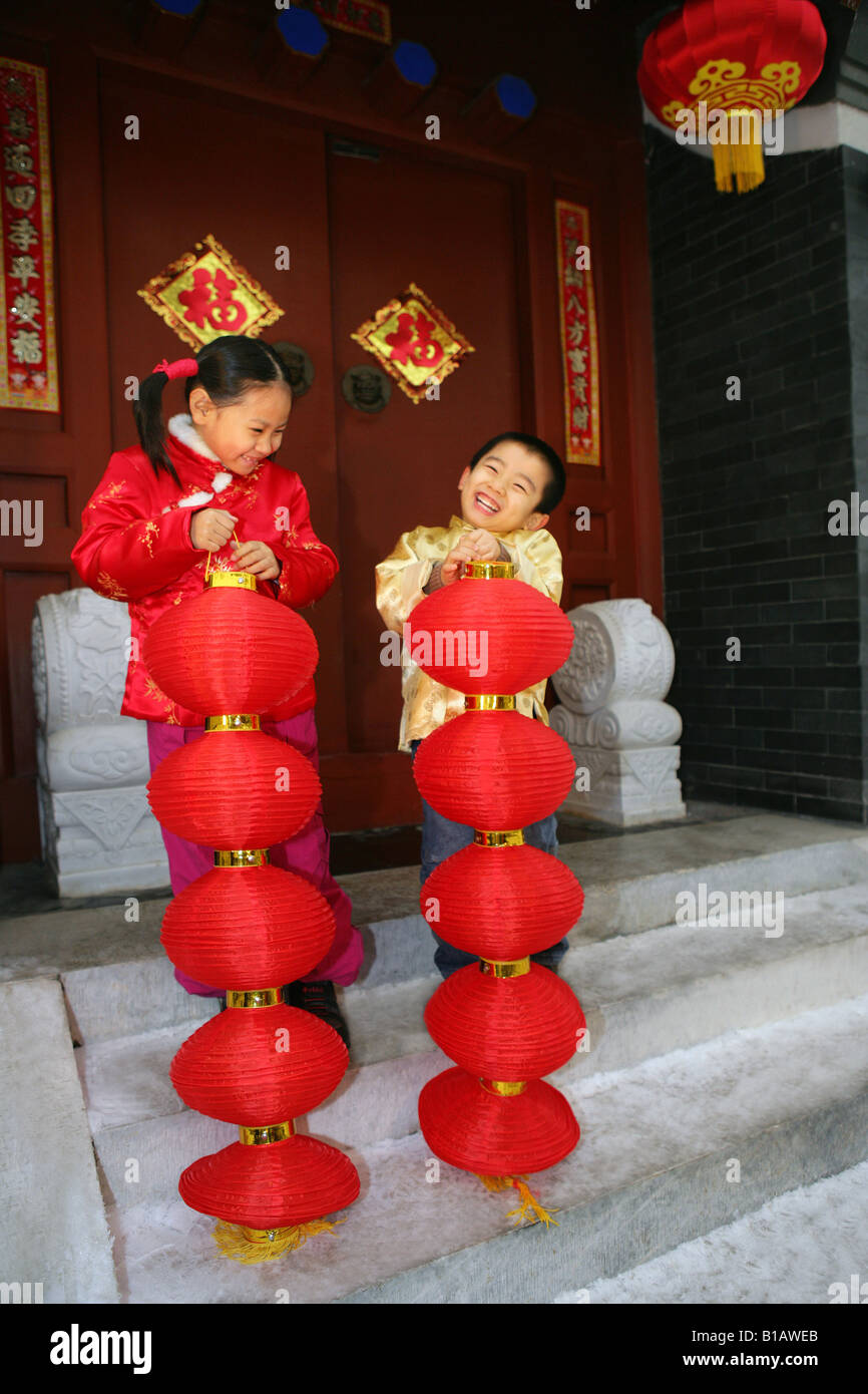 Two children(5-7 years) standing in front of chinese traditional house ...