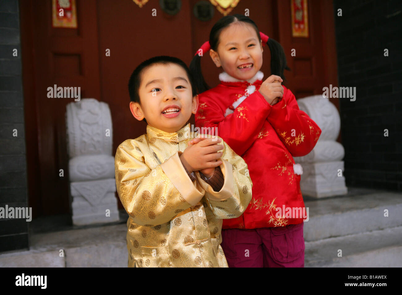 Two children(5-7 years) standing in front of chinese traditional house ...