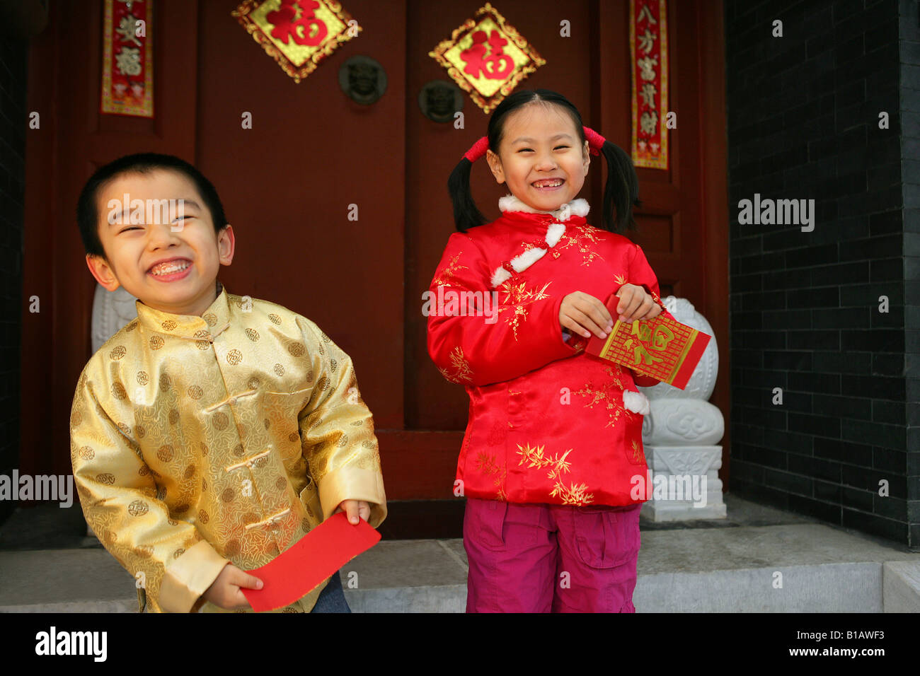 Two children(5-7 years) standing in front of chinese traditional house ...