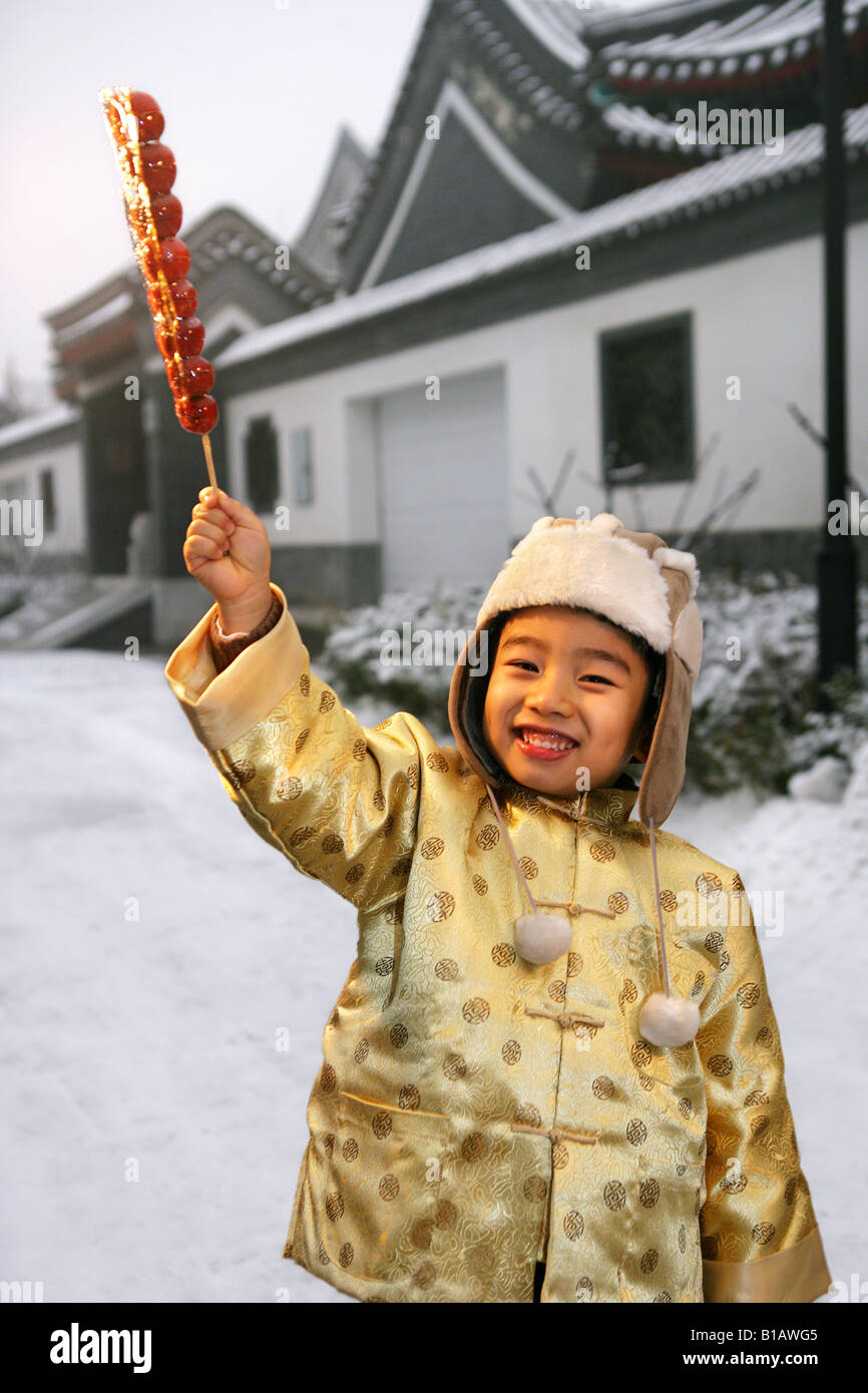 One chinese boy (4-5 years) standing in front of a Chinese traditional ...