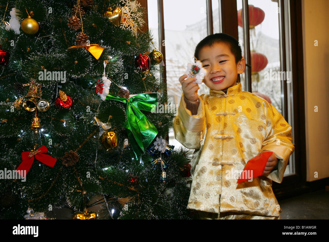 one chinese boy dressed in traditional clothing standing at a Christmas ...