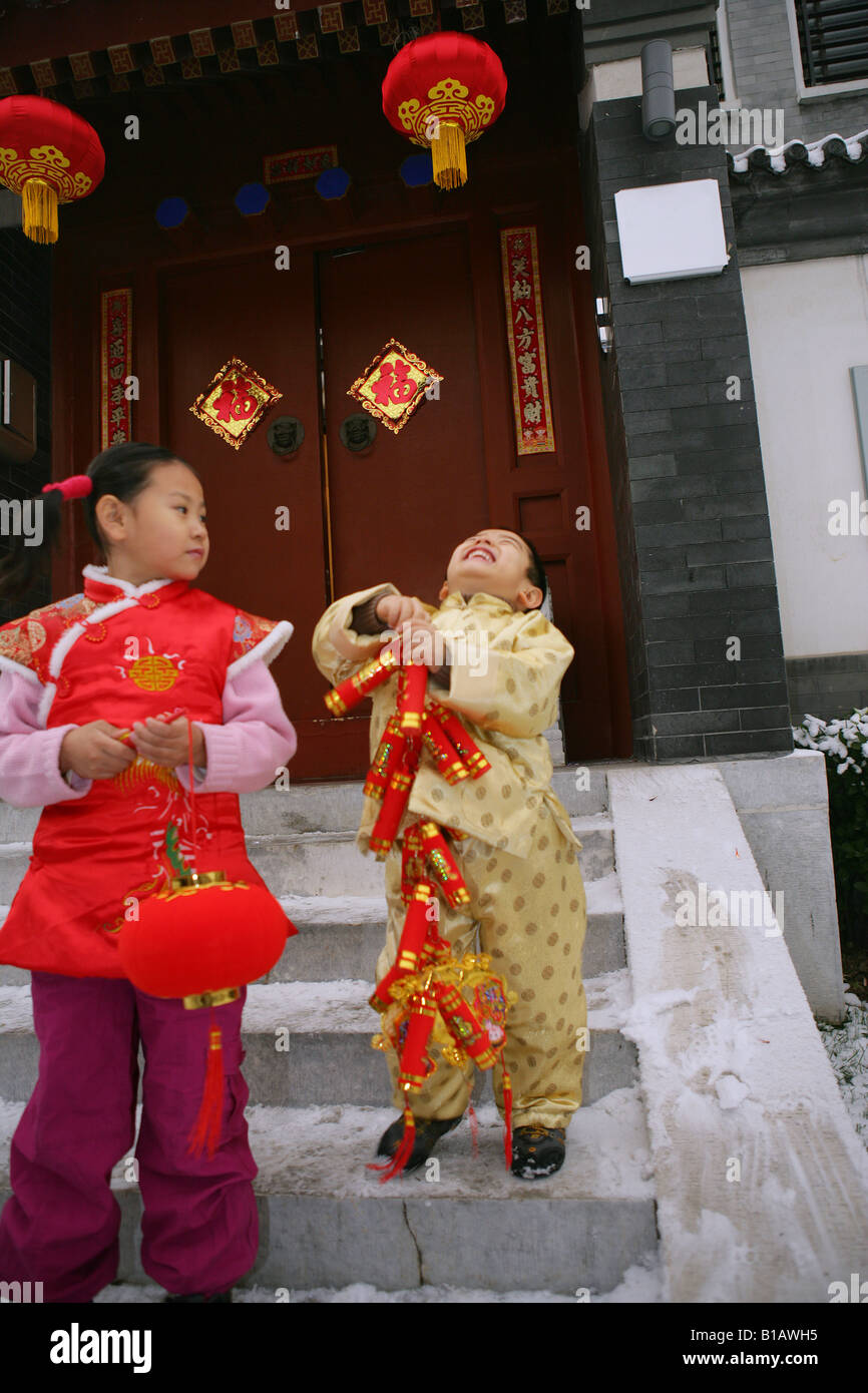 Two children(5-7 years) standing in front of chinese traditional house ...