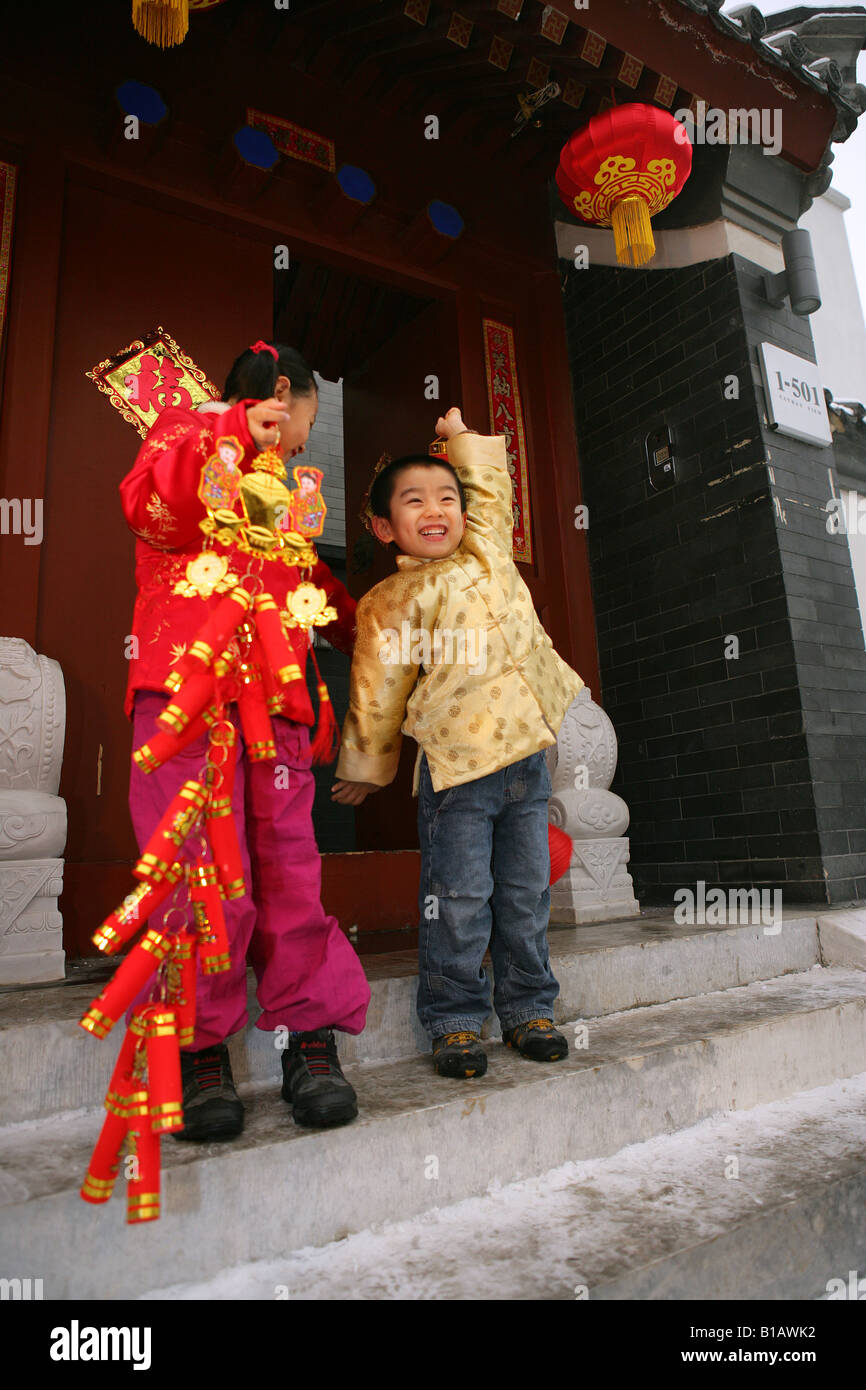 Two children(5-7 years) standing in front of chinese traditional house ...