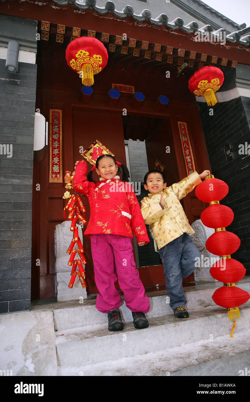 Two children(5-7 years) standing in front of chinese traditional house ...